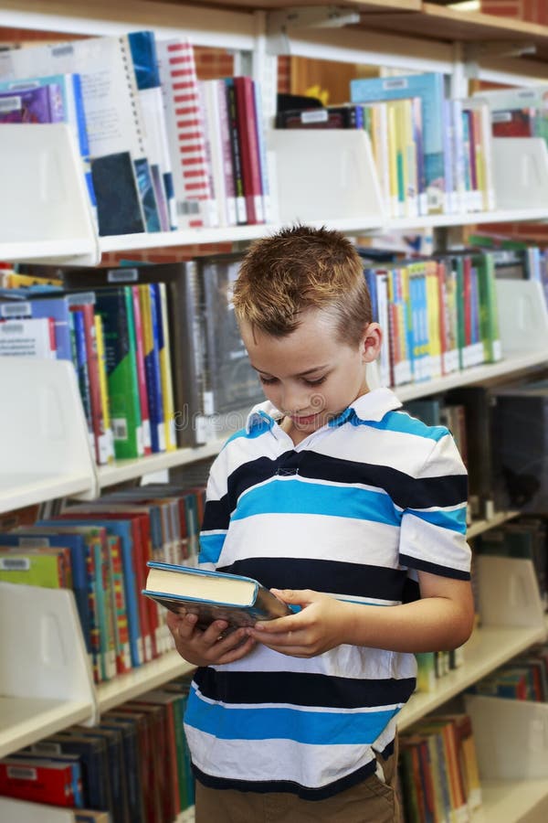 Child Reading a Book on a Couch at the Library Stock Photo - Image of ...