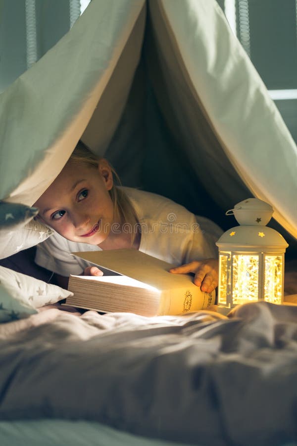 Child reading book in tent stock image. Image of dark - 100211825