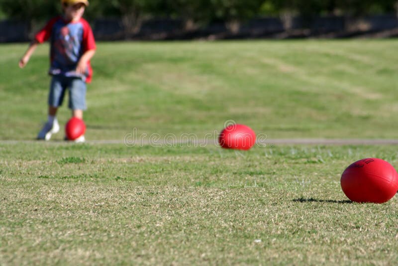 Child with red rugby balls stock photo. Image of field - 3749394