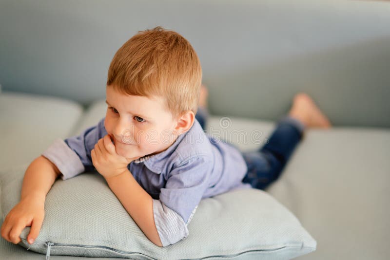 Child resting on sofa stock image. Image of home, looking - 73325683