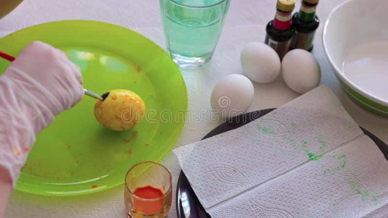 Child Rolling Hand-painted Easter Egg on Plate with Brush, Creating ...
