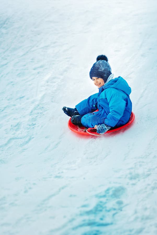 Child Rolls Down a Snow Hill. Boy Sliding Down Snow Hill in Winter ... Child Rolls Down a Snow Hill. Boy Sliding Down Snow Hill in Winter ...