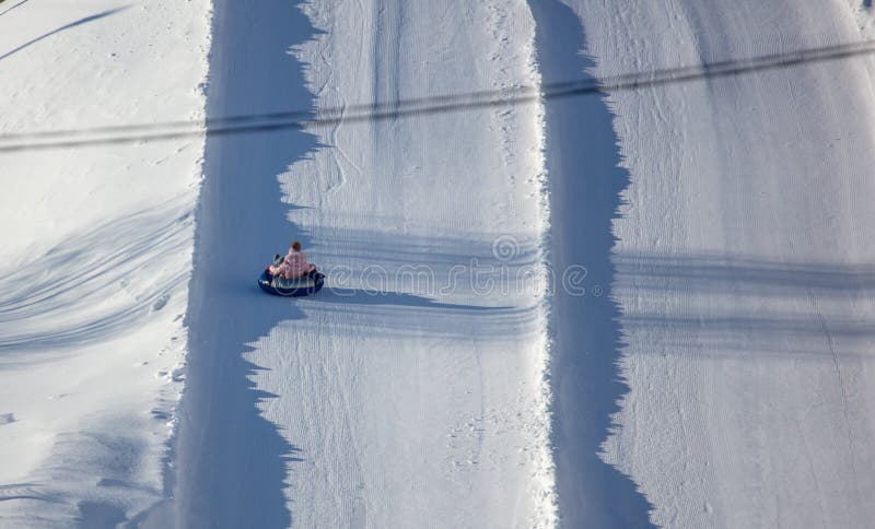 A Child Rolls Down a Snow Tubing from a Mountain. Stock Image - Image ...