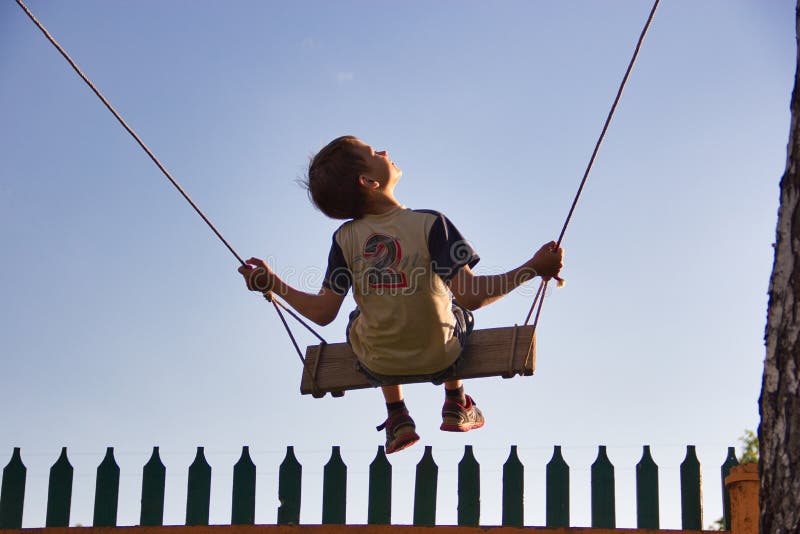 Child on a Rope Swing Against the Background of the Sky Stock Photo ...