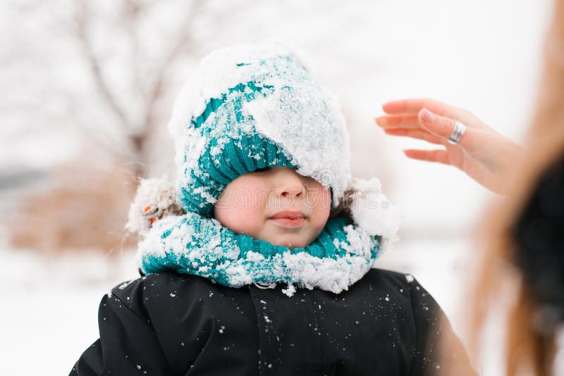Child S Face is Covered in Snow, and the Hat is Pulled Down Over the ...