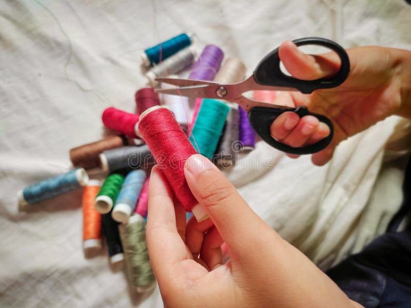 A Child& X27;s Hand Cutting Red Thread with Scissors and a Colorful ...