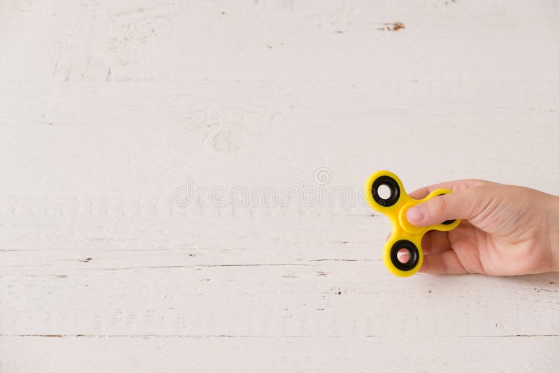 Child`s Hand Spinning a Fidget Spinner Device. Top View Stock Photo ...