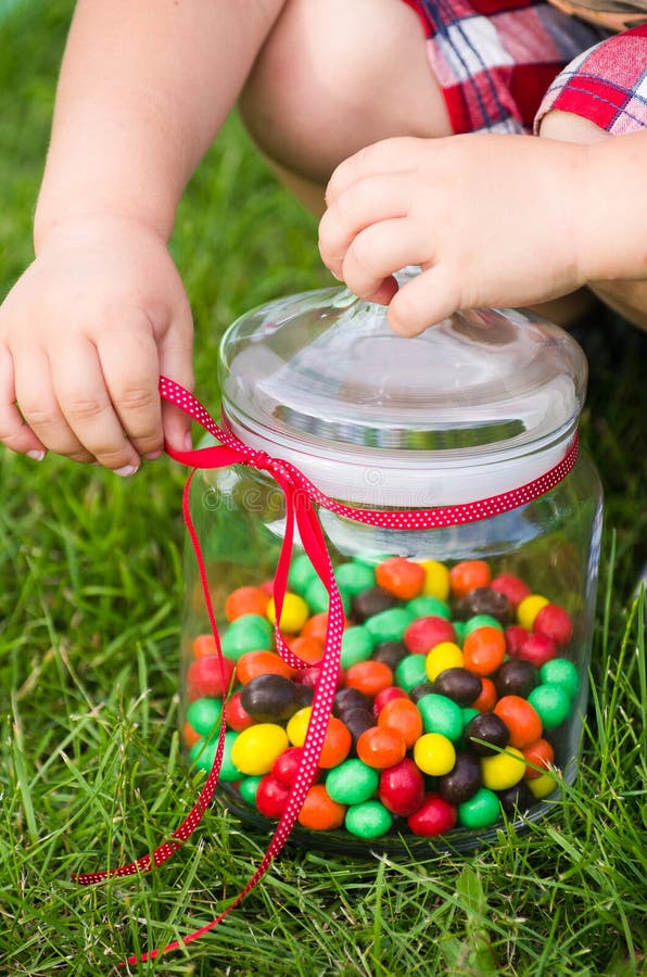 Child S Hands with a Candy Jar Stock Photo - Image of glass, grass ...