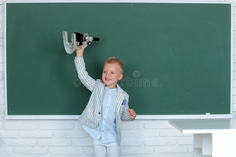 Child at School. Kid is Learning in Class on Background of Blackboard ...