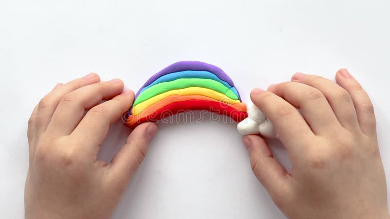 The Child Sculpts a Rainbow and Clouds from Plasticine. Children S ...