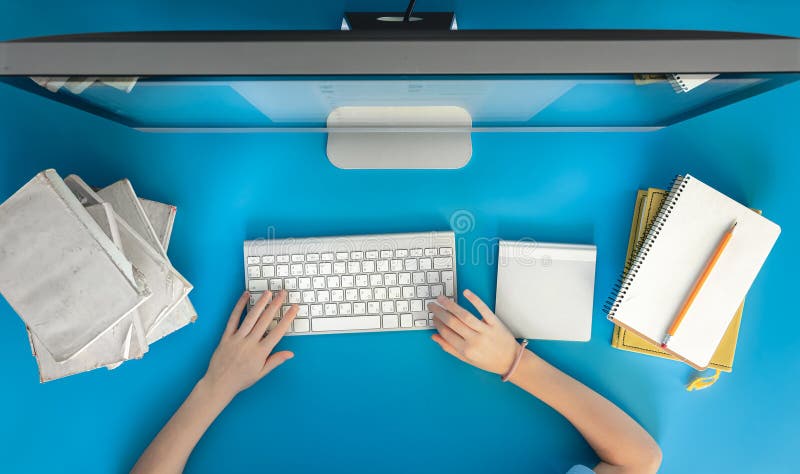 A Child Sits in Front of a Computer with Notepads and Books, Top View ...