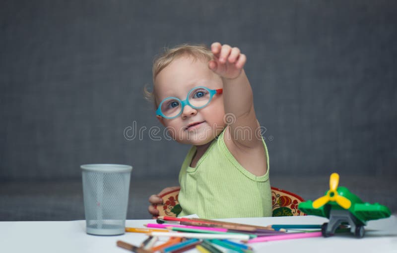 A Child Sitting at a Desk with Paper and Colored Pencils Stock Image ...