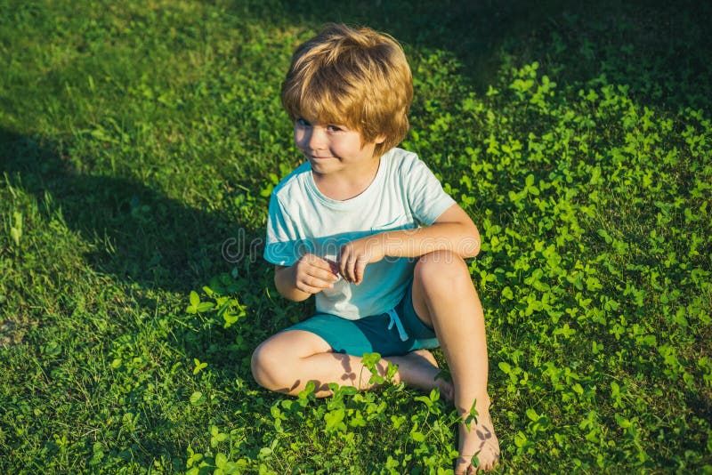 A Child is Sitting on the Grass. Happy Sunny Day Outside. Stock Image ...