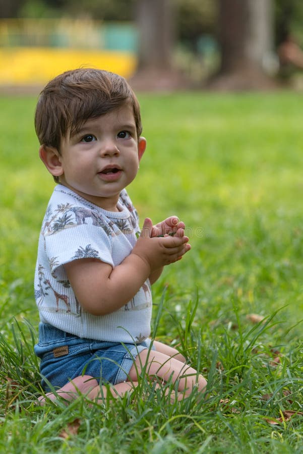 Child Sitting on the Grass in a Park. Stock Image - Image of sitting ...