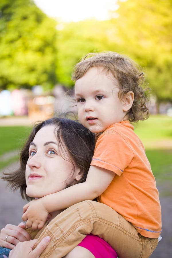 The Child is Sitting on Mum S Shoulders. Stock Image - Image of ...