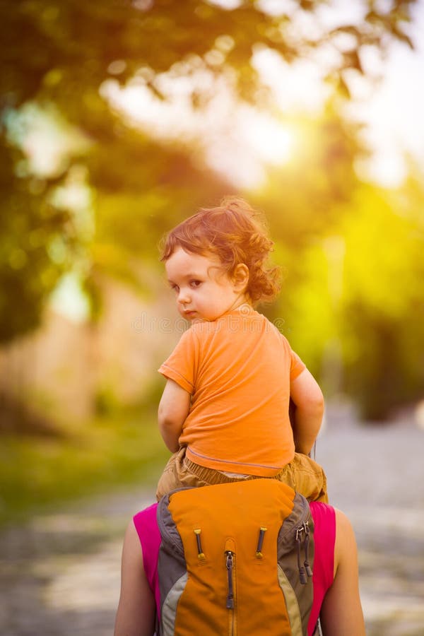 The Child is Sitting on Mum S Shoulders. Stock Image - Image of ...