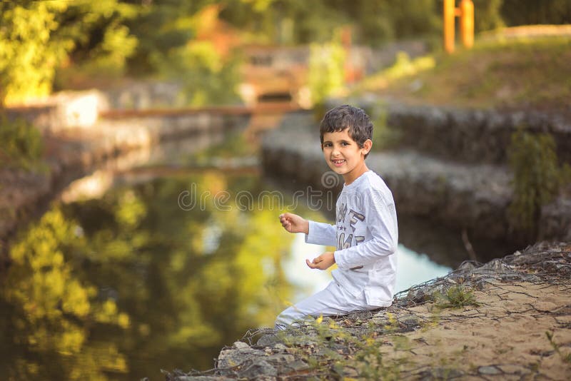 A Child is Sitting Near the Lake. Summer Time Stock Photo - Image of ...