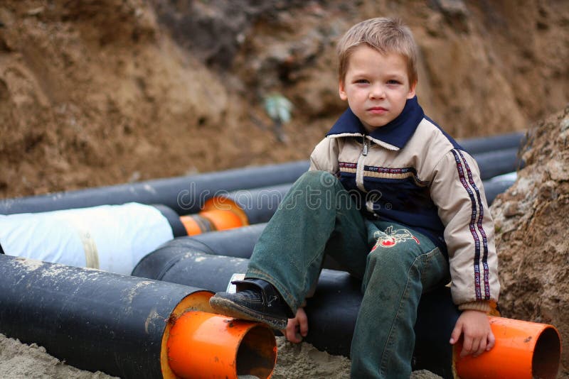 Child sitting on a pipe stock image. Image of serious - 6649277