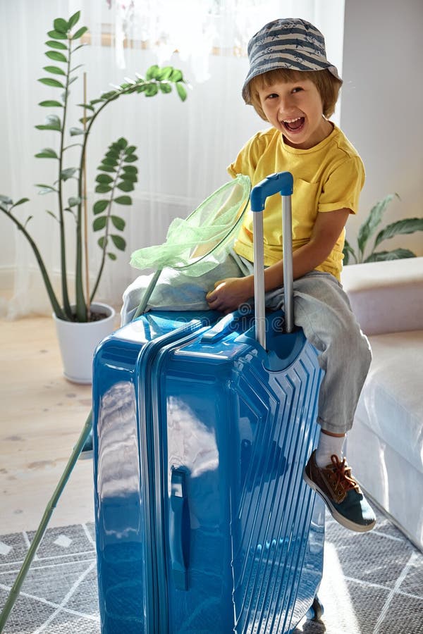 A Child Sitting on a Suitcase Have Fun and Laughs, Waiting for a Trip ...