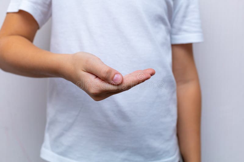 A Child is Sitting at a Table, Folding His Hands Neatly Stock Photo ...