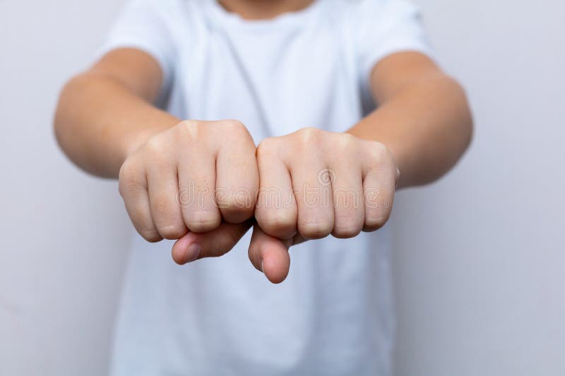 A Child is Sitting at a Table, Folding His Hands Neatly Stock Image ...