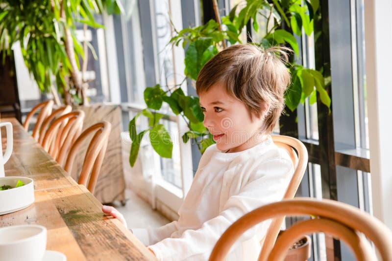 A Child Sitting at the Table and Smiling Stock Image - Image of ...