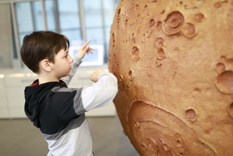 Child spins model of moon editorial photo. Image of male - 249290316