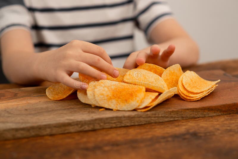 Child Stacking Crispy Potato Chips, Casual Snack on Rustic Wood. Stock ...