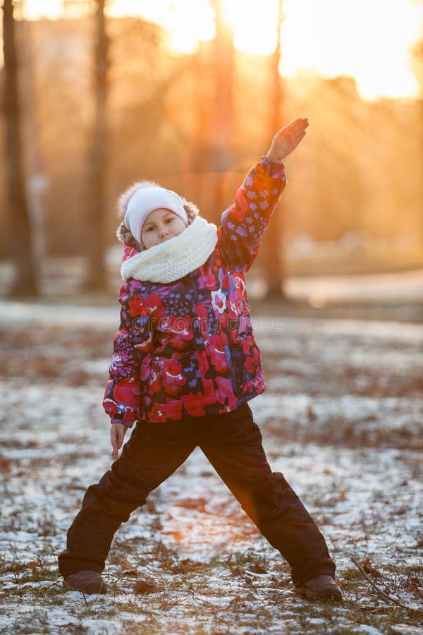 Child Standing in the Rays of the Setting Sun with Raised Hand, Winter ...