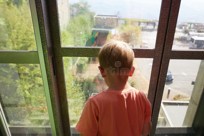 The Child is Standing by the Window in a High-rise Building. Stock ...