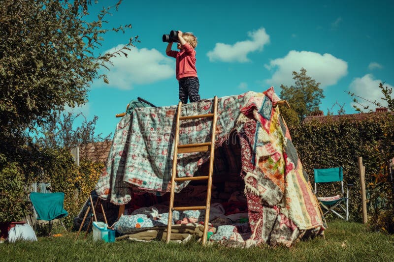 A Child Stands on a Makeshift Fort Made of Blankets and a Ladder. they ...