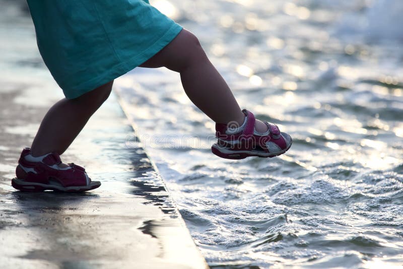 Child steps into the water stock photo. Image of danger - 126373222