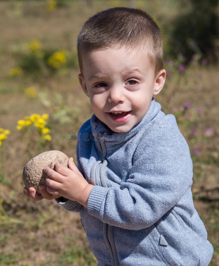 Child with a stone stock image. Image of caucasian, blond - 46185439