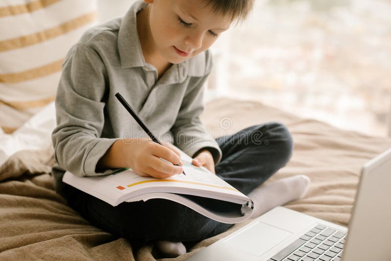 Child Student Sitting on Bed, Writing in Notebook. Home Schooling ...