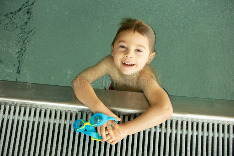 Child, Taking Swimming Lessons in a Group of Children in Indoor Pool ...