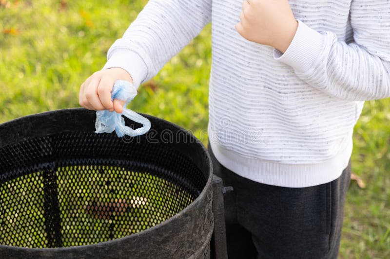 A Child Throws a Plastic Bag in the Trash. Concept of Garbage Recycling ...