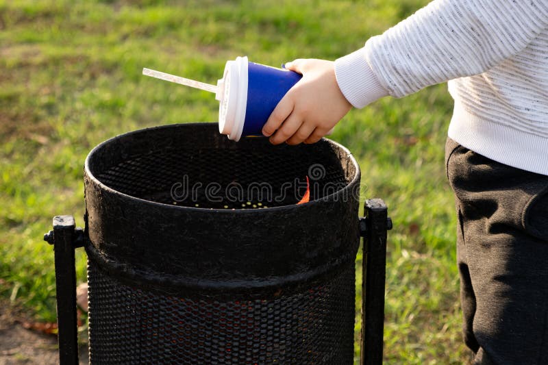 A Child Throws a Plastic Bag in the Trash. Concept of Garbage Recycling ...