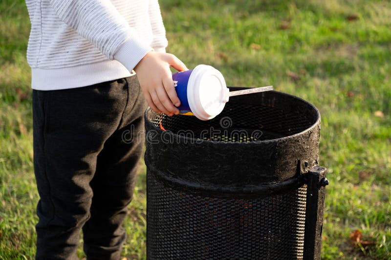 A Child Throws a Plastic Cup in the Trash. Garbage Recycling and ...