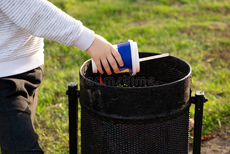A Child Throws a Plastic Cup in the Trash. Garbage Recycling and ...