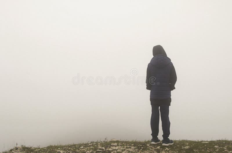 A Child on Top of a Mountain in Stands in the Fog Stock Photo - Image ...