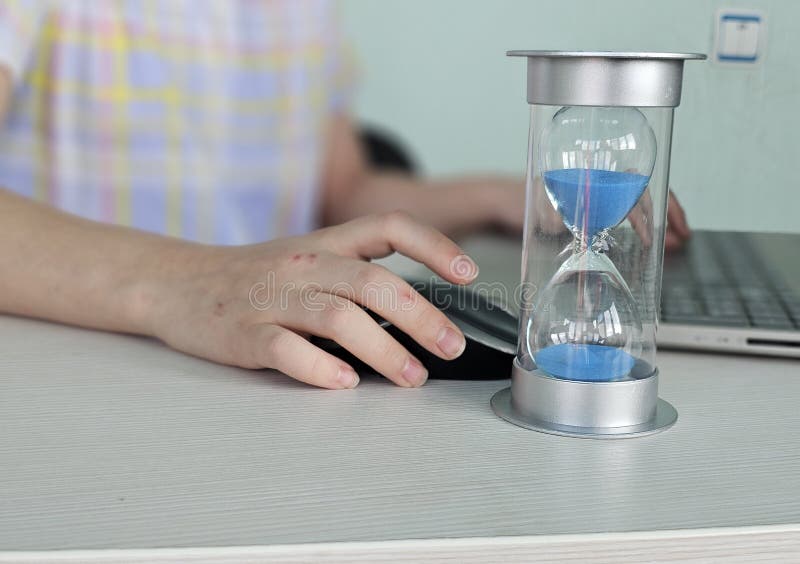 A Child Using a Computer with an Hourglass Timer Stock Image - Image of ...
