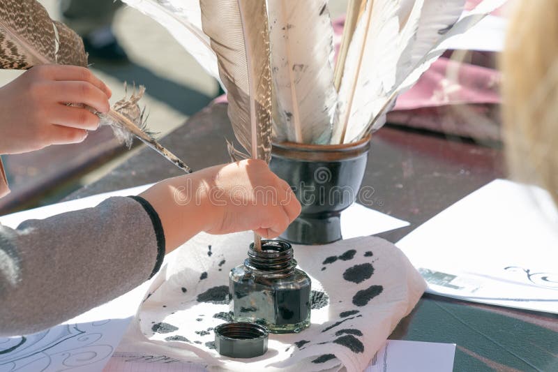Child Using Feather Quill and Ink Jar for Writing on Paper Outdoors ...