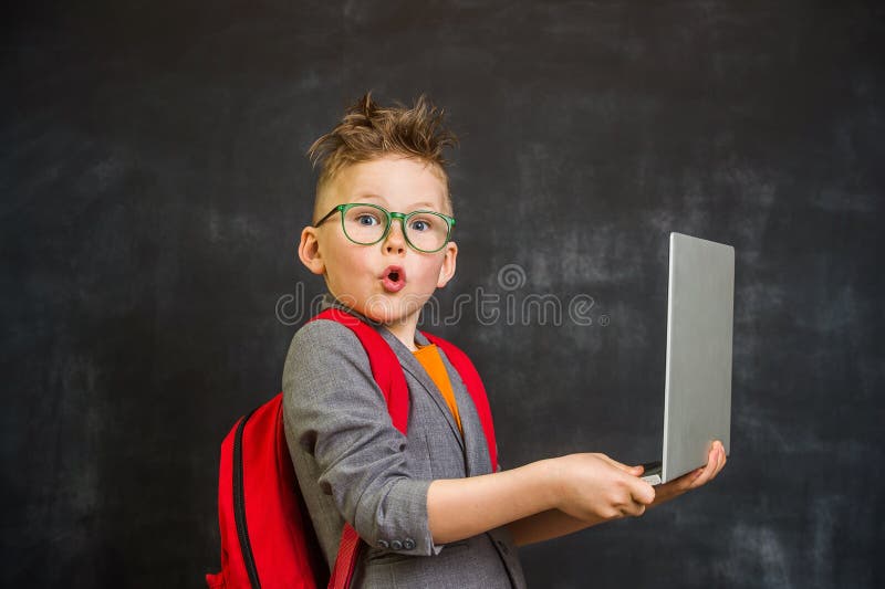 Child Using a Laptop Computer with Blackboard Background. Stock Image ...