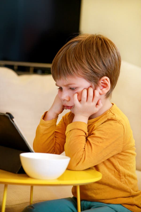 Child Using Tablet Pc on Bed at Home. Cute Boy on Sofa is Watching ...