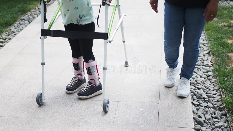 Child with Walking Frame and Knee Orthosis Outdoor Stock Video - Video ...