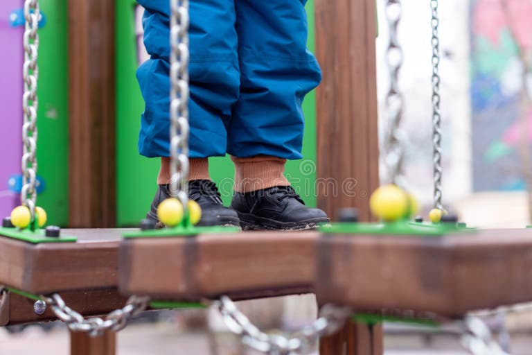 Child Walking on Playground Bridge with Chains and Colorful Wooden ...
