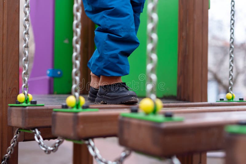 Child Walking on Playground Bridge with Chains and Colorful Wooden ...