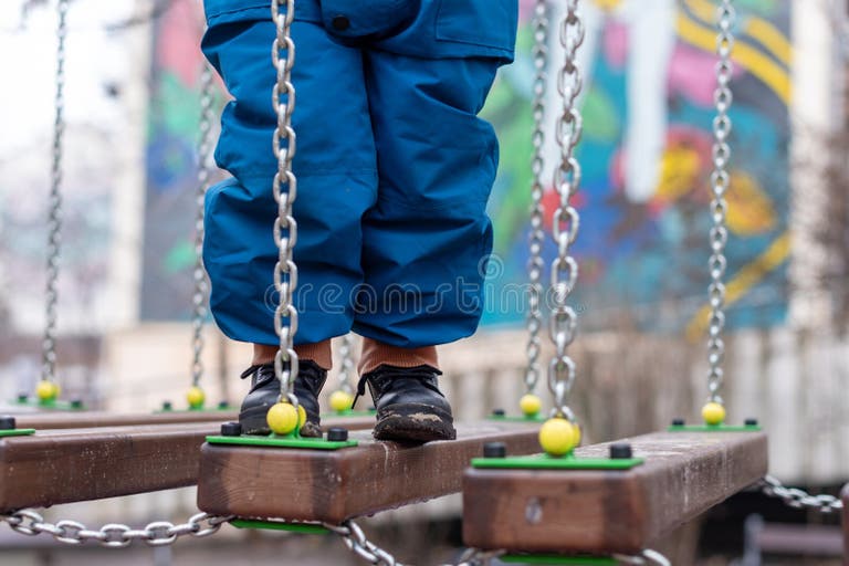 Child Walking on Playground Bridge with Chains and Colorful Wooden ...