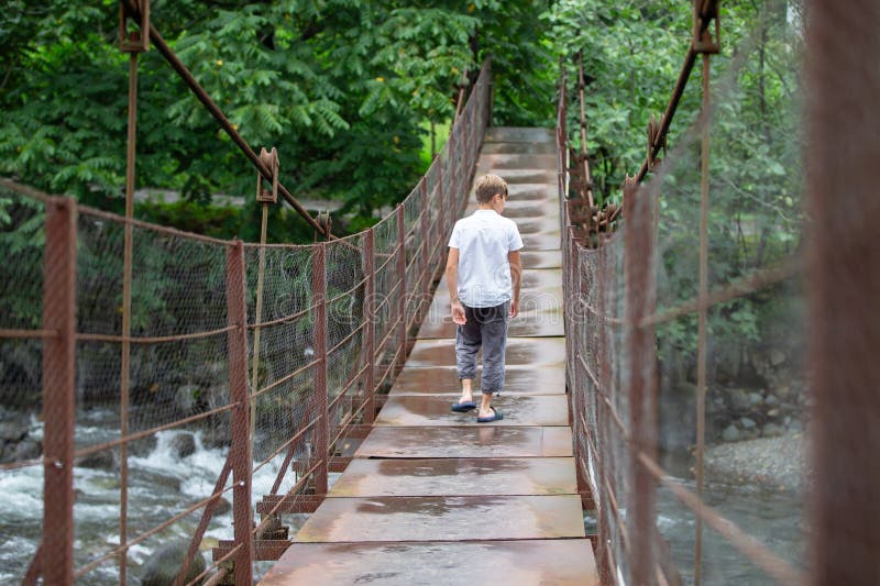 A Child Walks Along a Suspension Bridge Stock Image - Image of hiking ...