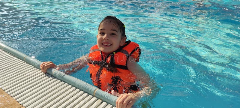 Child Wearing Life Jacket Smiling in Pool on Sunny Day Stock Photo ...